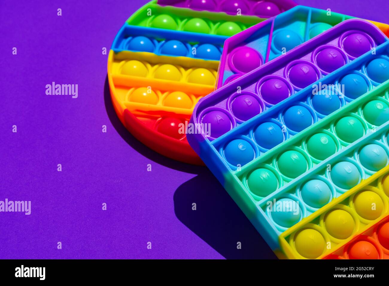 Colorful antistress pop it toy on purple background Stock Photo - Alamy