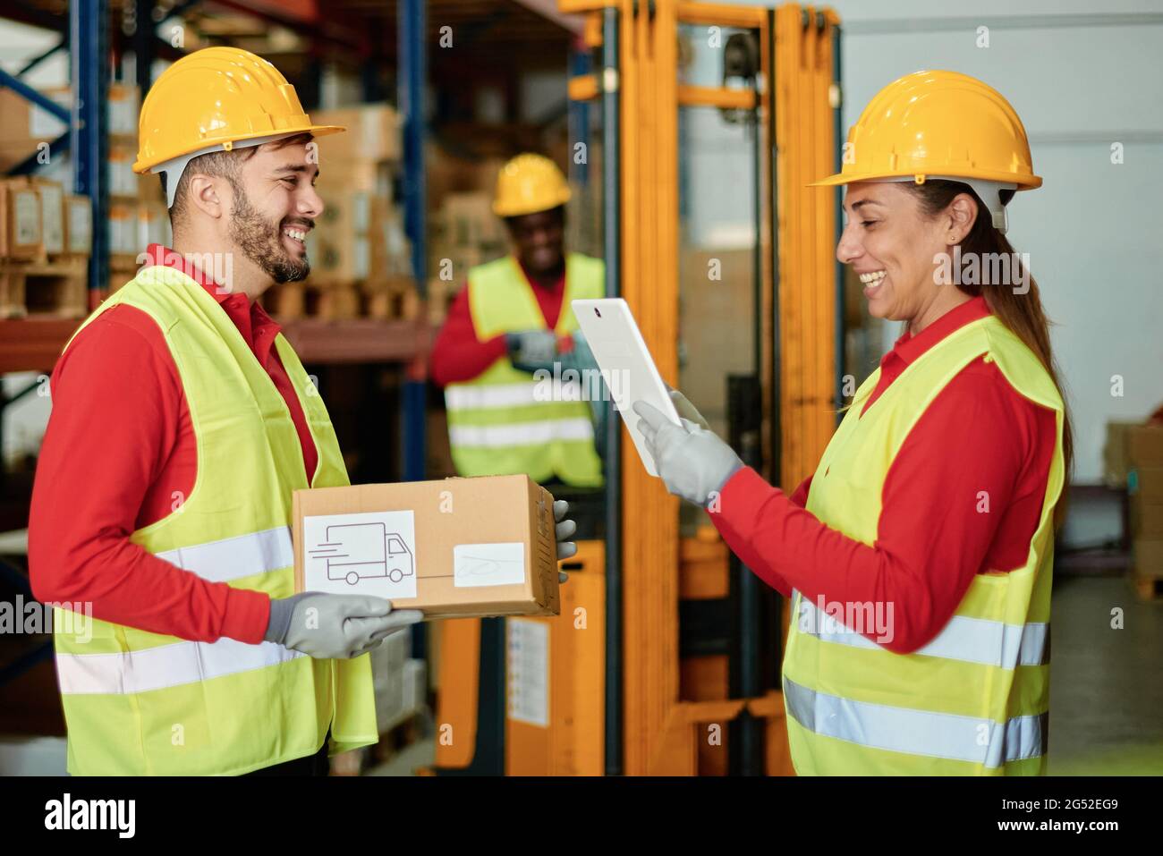 Cheerful warehouse workers with parcel and tablet Stock Photo - Alamy