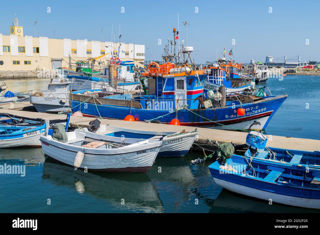 View of the small fishing port of Setubal with its typical blue boats ...
