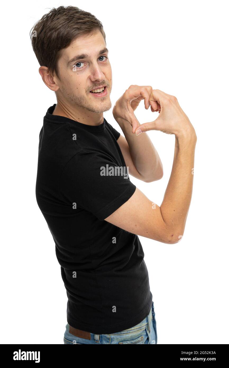 Young handsome tall slim white man with brown hair doing heart gesture ...