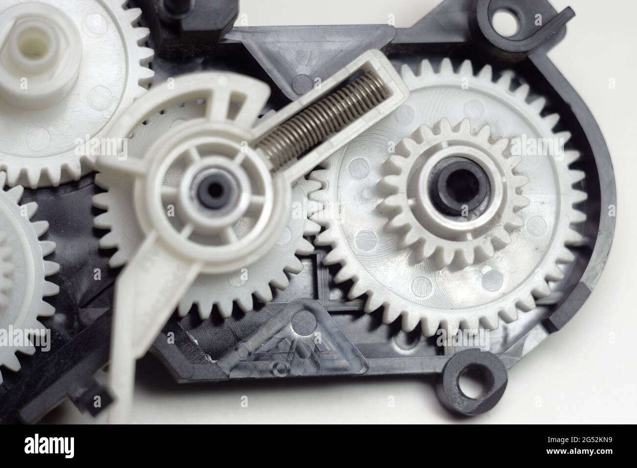 multiple reducer gears of white plastic, spring and black case are ...