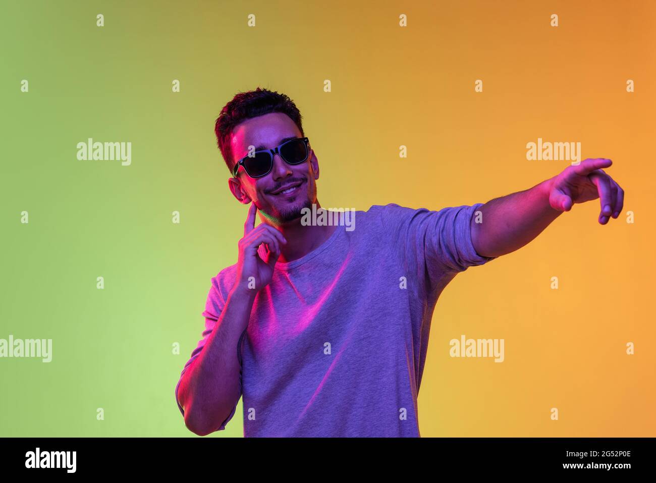 Portrait of Latina young man in sun glasses posing isolated on gradient ...