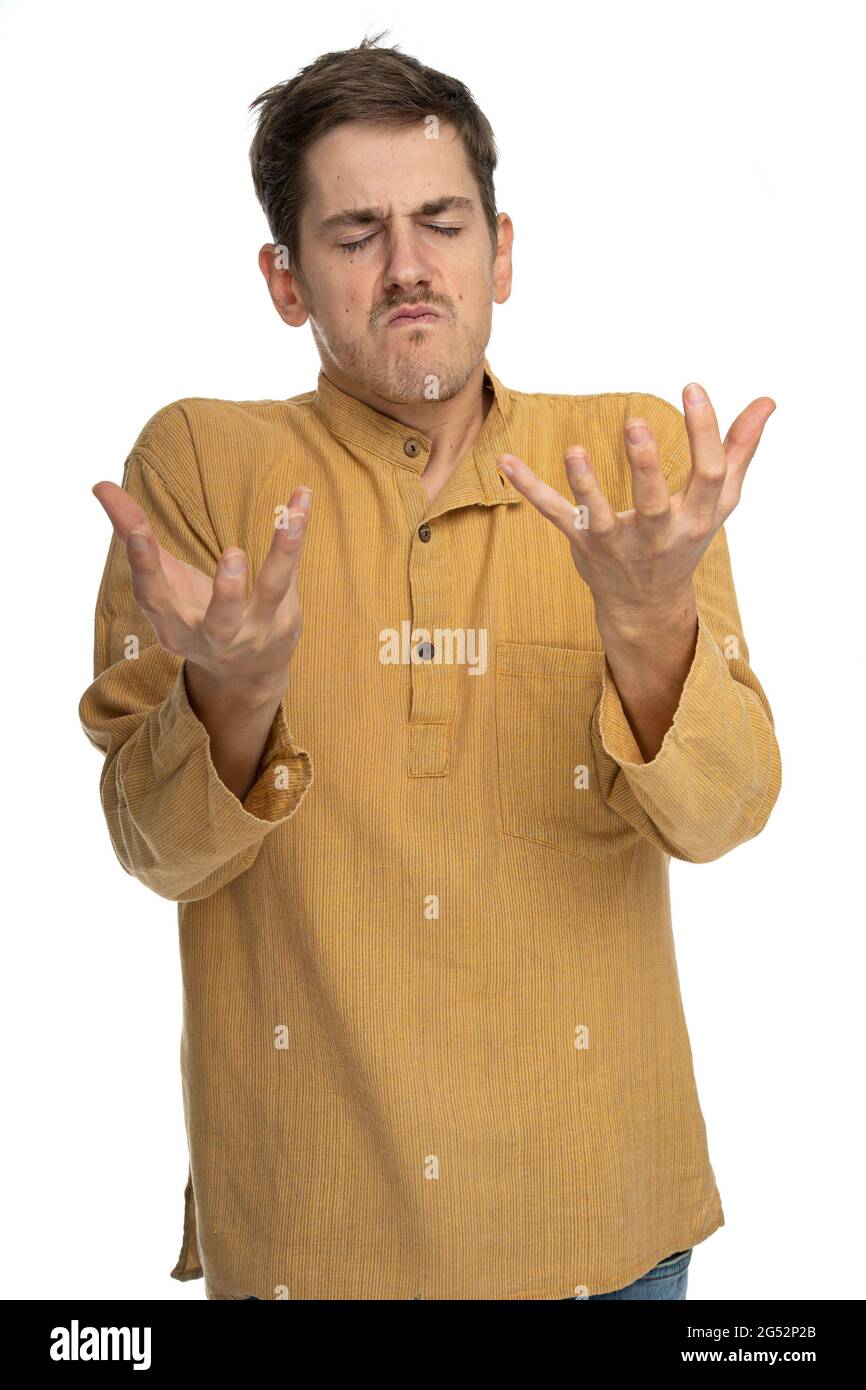 Young handsome tall slim white man with brown hair looks angry in ochre ...