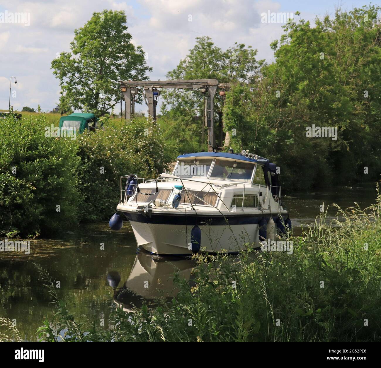 On a bright summers afternoon a fibreglass cruiser boat navigates along ...