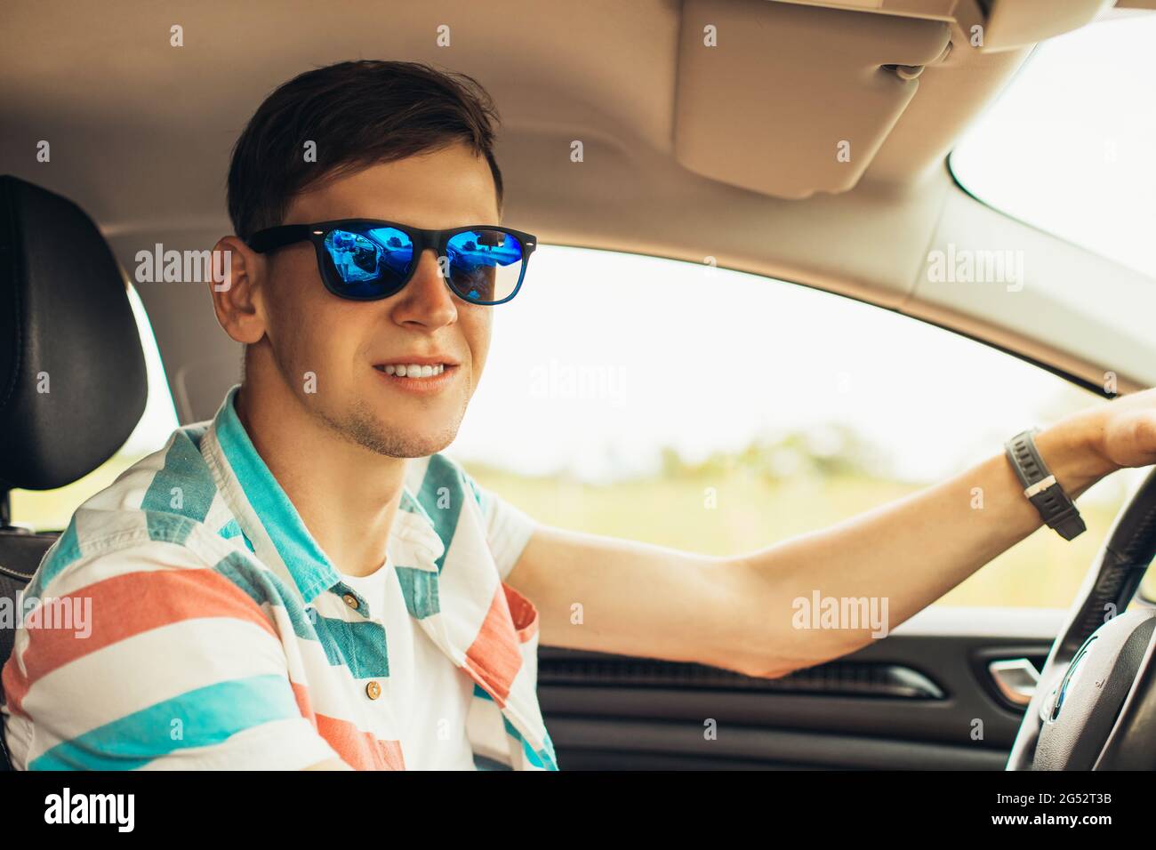Riding his new car, side view of a handsome young smiling young man ... Riding his new car, side view of a handsome young smiling young man ...