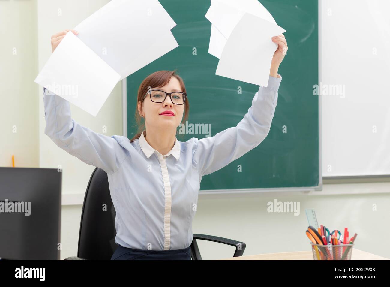 cute young woman teacher at school at her workplace sitting at the ...