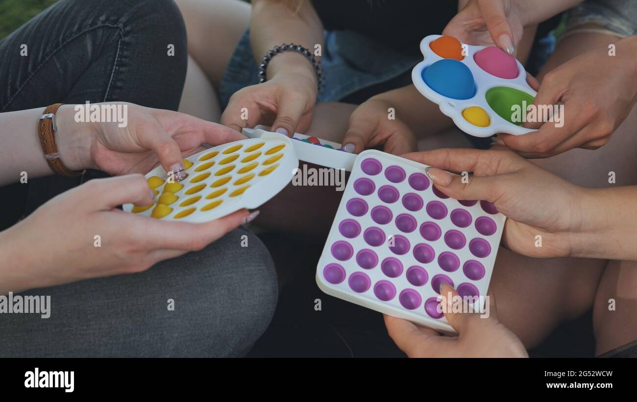 Girls play with simple dimple relaxing toys and pop it Stock Photo - Alamy