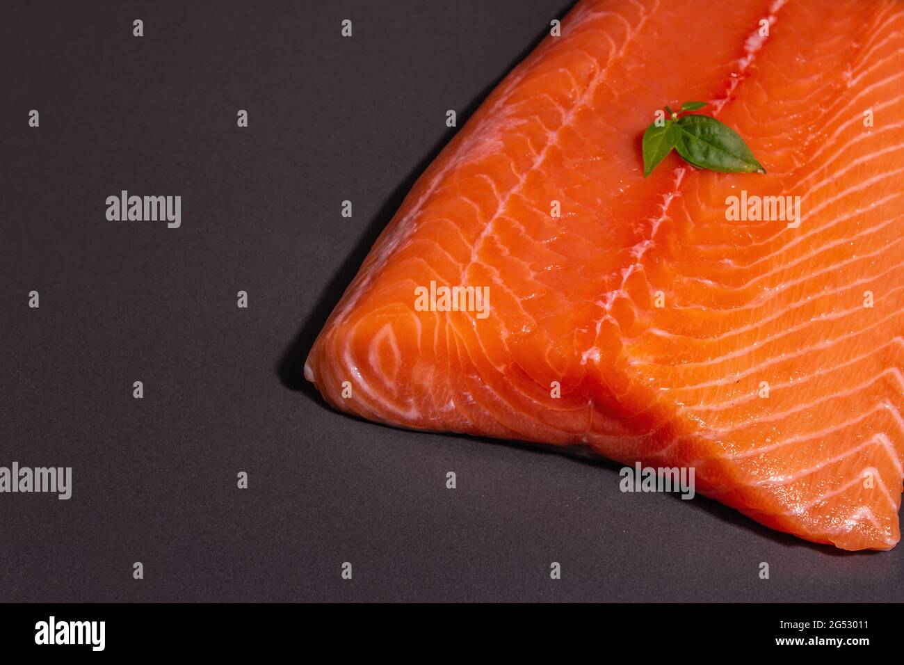 Fresh raw salmon or trout sea fish fillet on black stone background ...