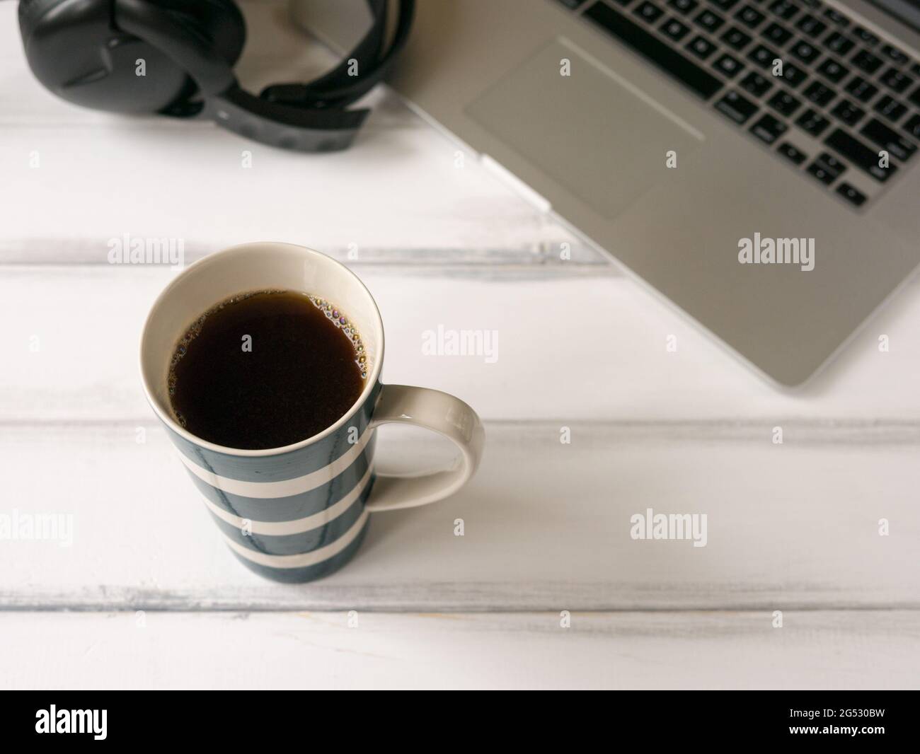 White wooden working desk with laptop and large mug of coffee Stock ...