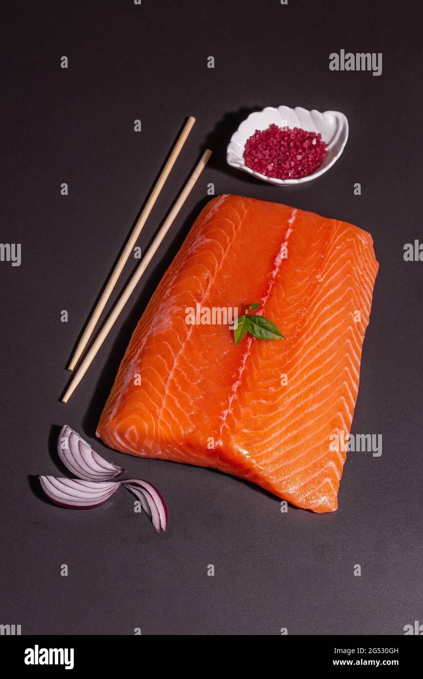 Fresh raw salmon or trout sea fish fillet on black stone background ...