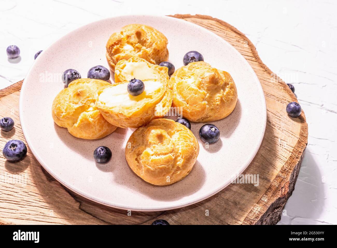 Profiteroles with blueberries. Custard cakes, Eclair, cream puff on a ...