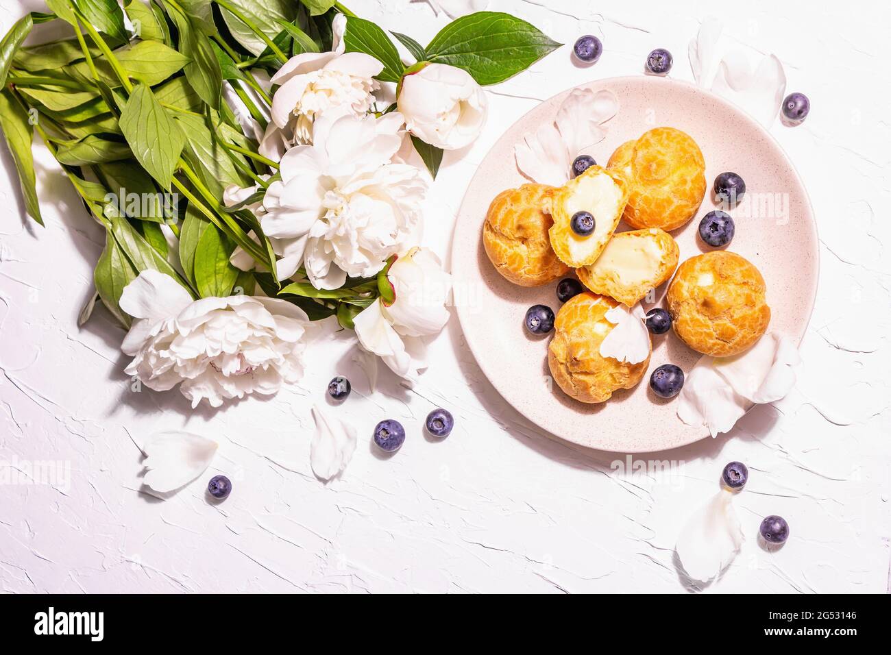 Profiteroles with blueberries. Custard cakes, Eclair, cream puff ...