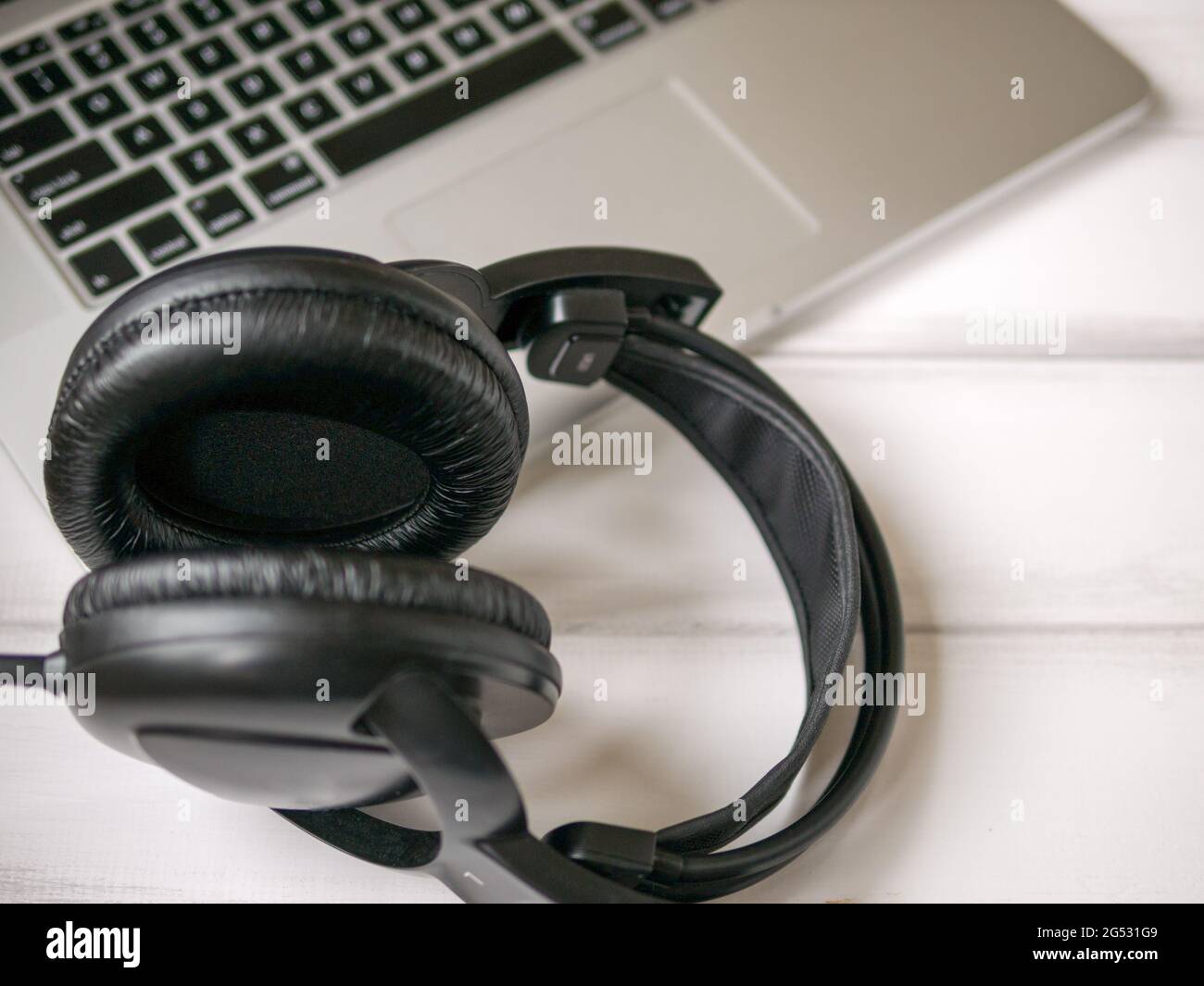 Wooden working desk with notebook and headphones Stock Photo - Alamy