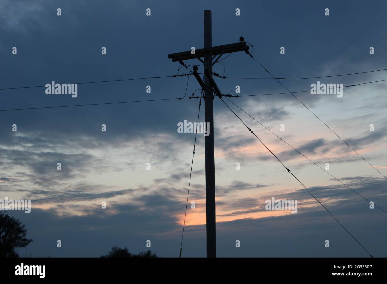 Telephone pole forming a cross shape in front of the sunset Stock Photo ...