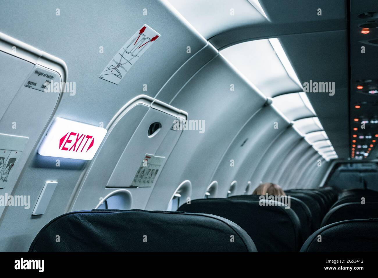 The exit sign inside the aircraft and cabin lights Stock Photo - Alamy