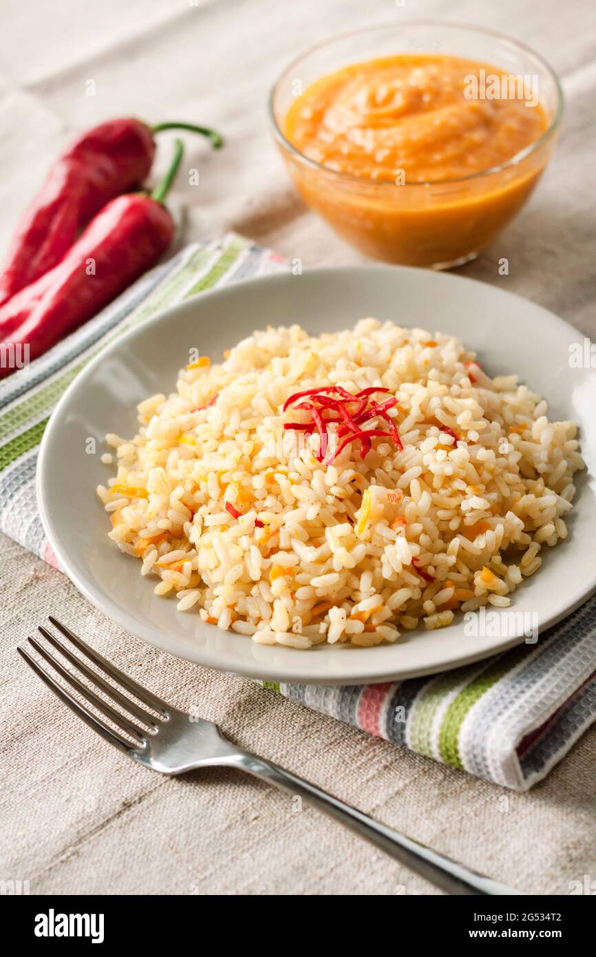 Spicy parboiled rice with carrots, yellow zucchini and chili peppers on ...
