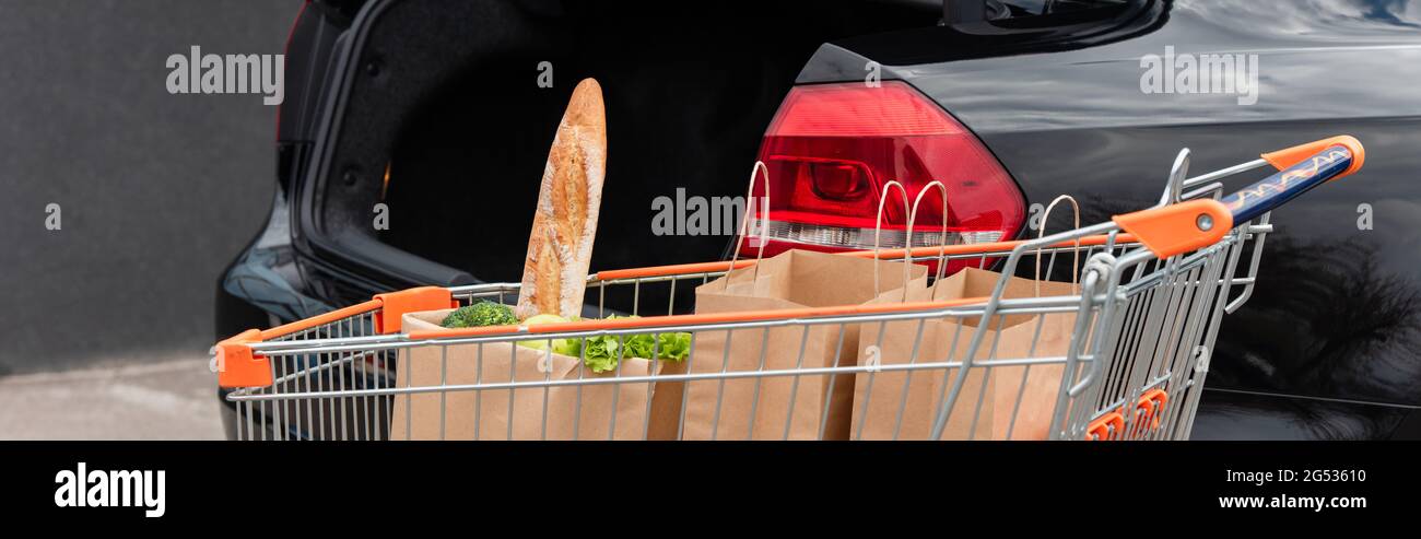 shopping cart with purchases near open car trunk, banner Stock Photo ...