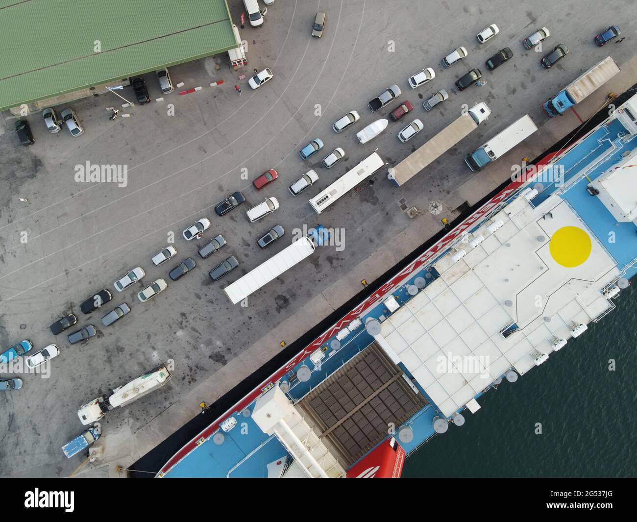 aerial view cars lorries waiting to be loaded In ferry ships at dock in ...