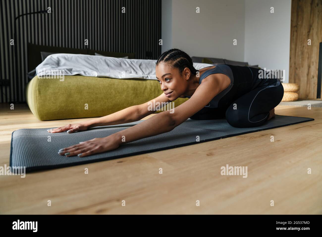 Attractive young healthy african woman doing yoga exercises on a ...