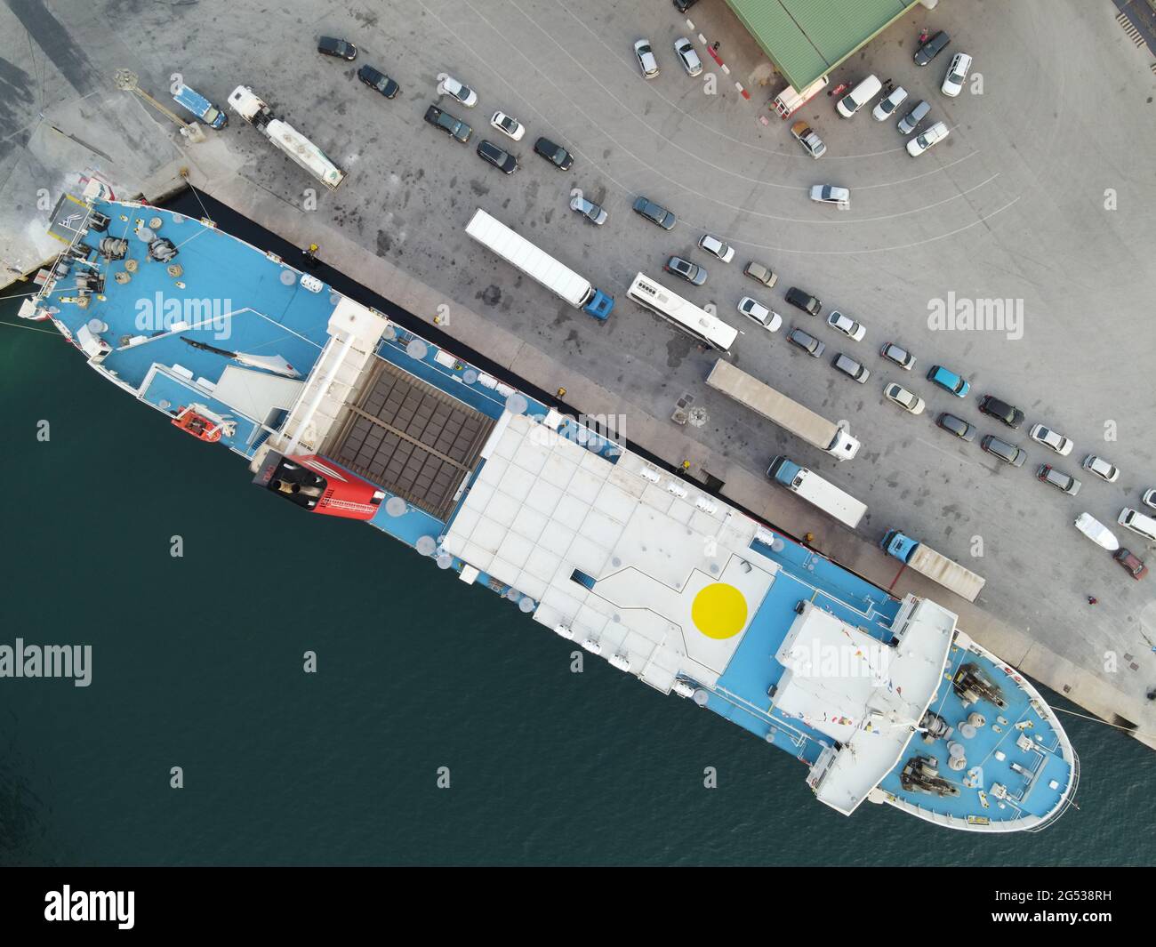 aerial view cars lorries waiting to be loaded In ferry ships at dock in ...
