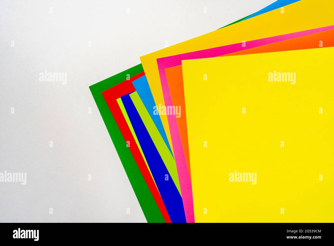 stack of of color paper sheets on the table flat lay, view from above ...