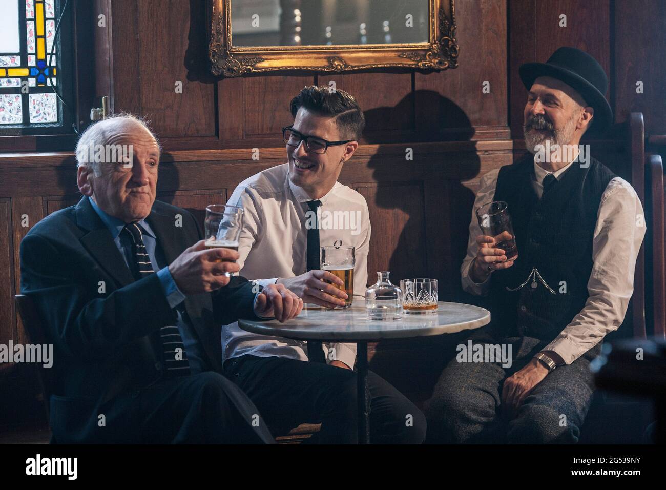 Three happy men drinking in pub interior ,England, London, Tower ...