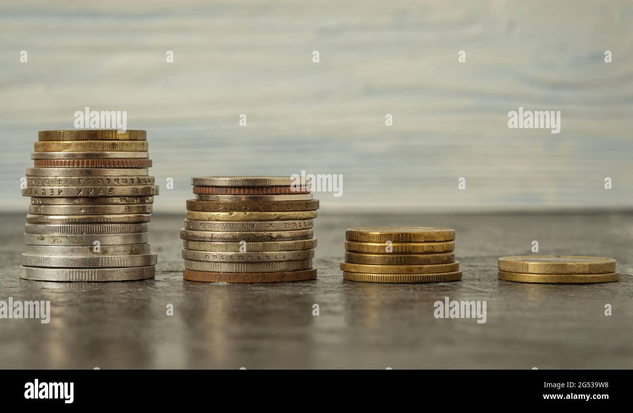 On a black background, there are four stacks of coins in descending ...