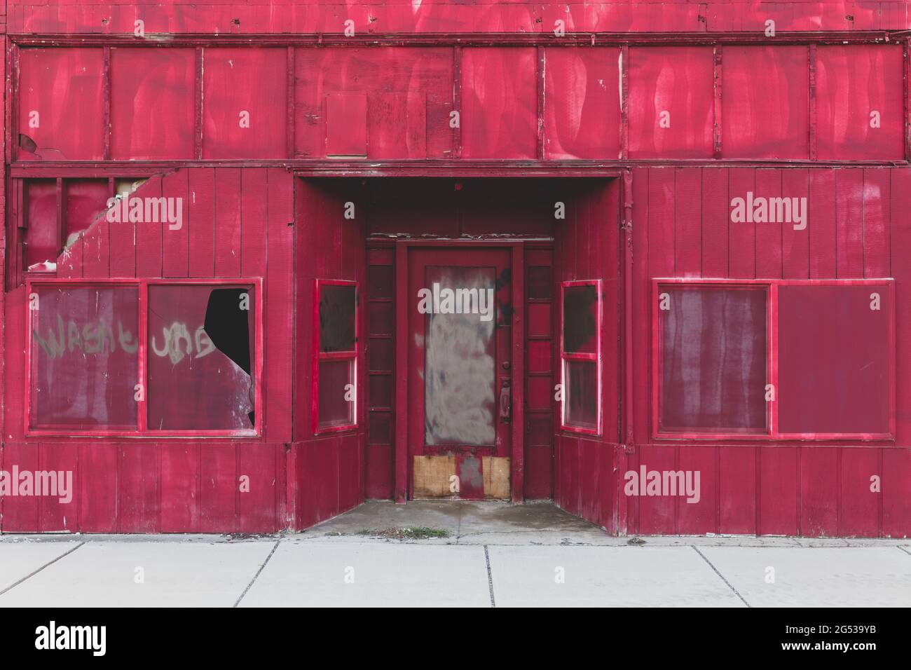 Boarded up building with broken windows on a main street Stock Photo ...