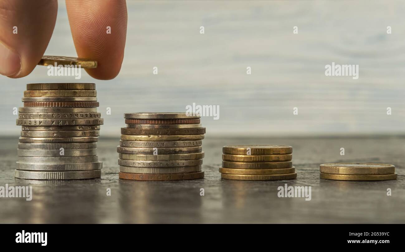 On a black background, there are four stacks of coins in descending ...