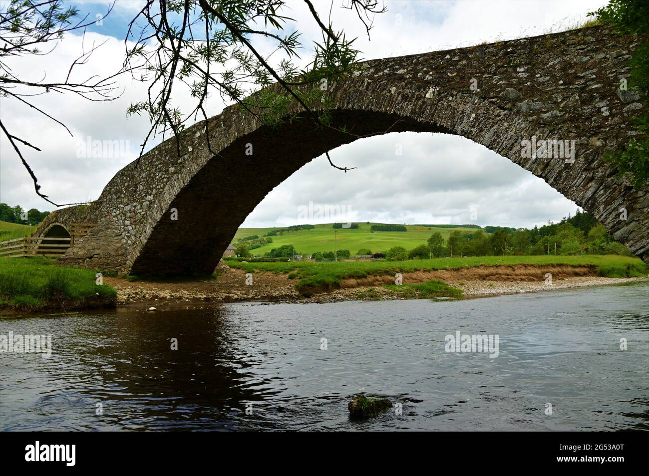 A view of an old stone arch bridge over the Gala water in the borders ...