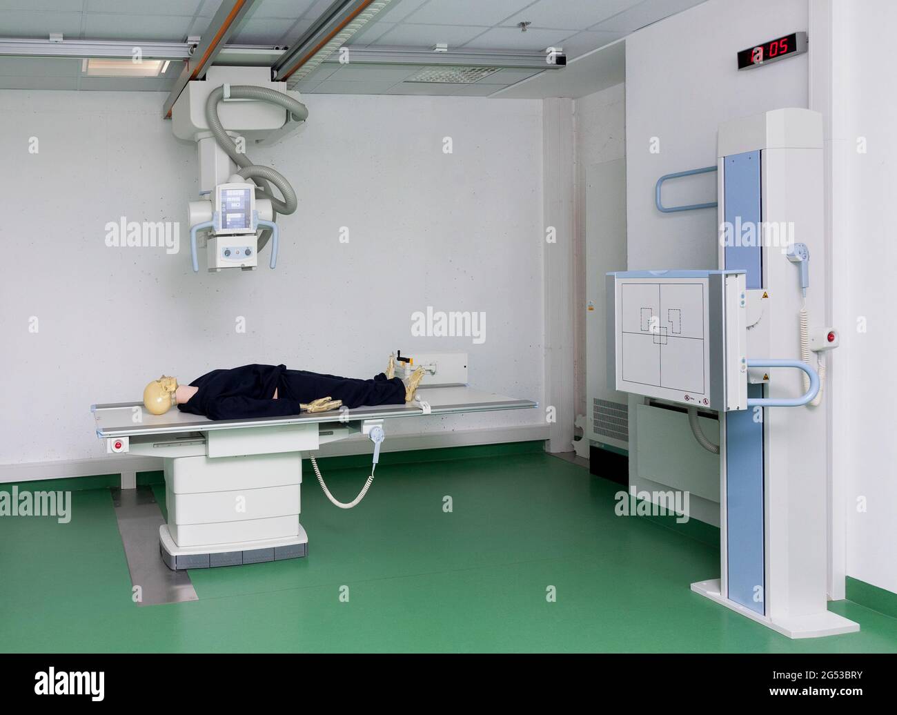 Mannequin lying on a table under an x ray machine in a training college ...