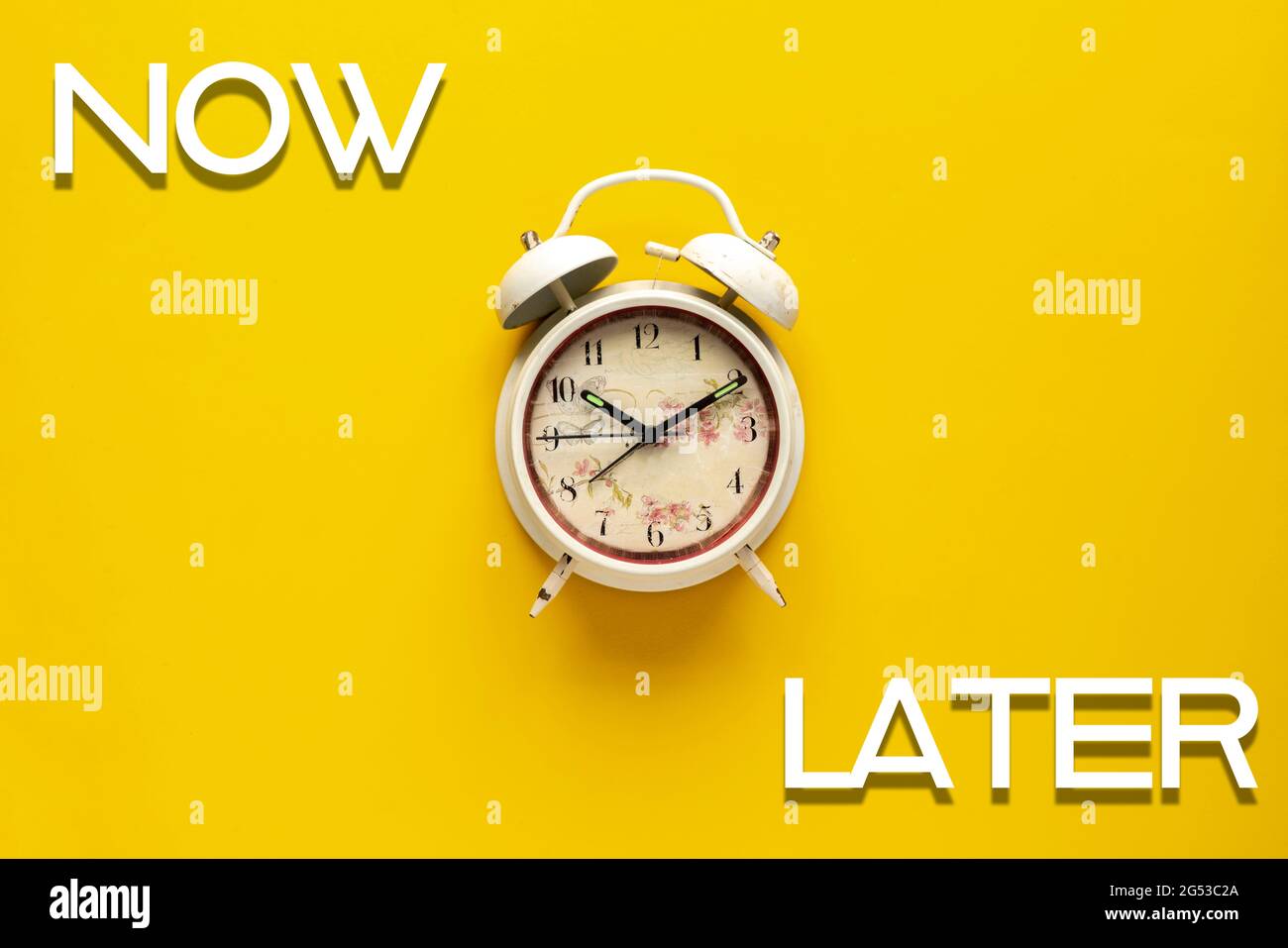 simple retro alarm clock on color background with words now and later ...