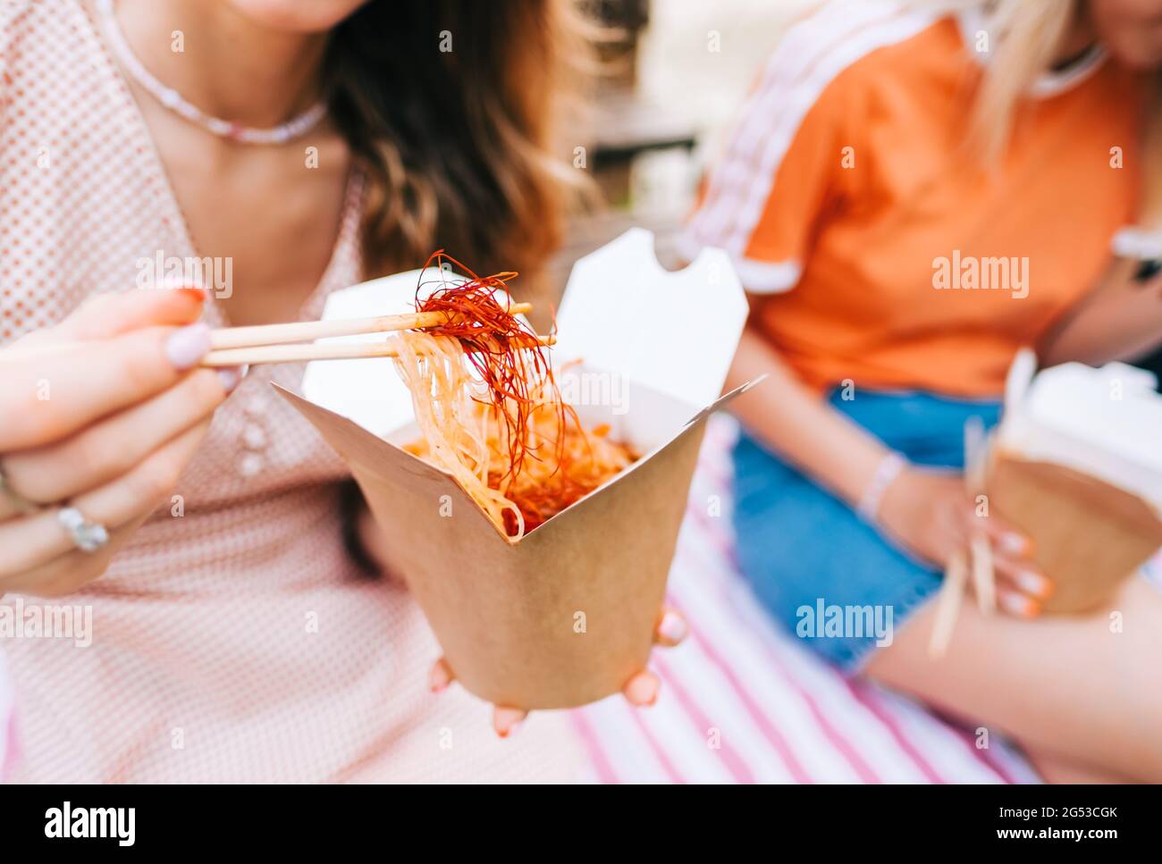 Friends eating street food outdoor on the park, enjoying summer weather ...