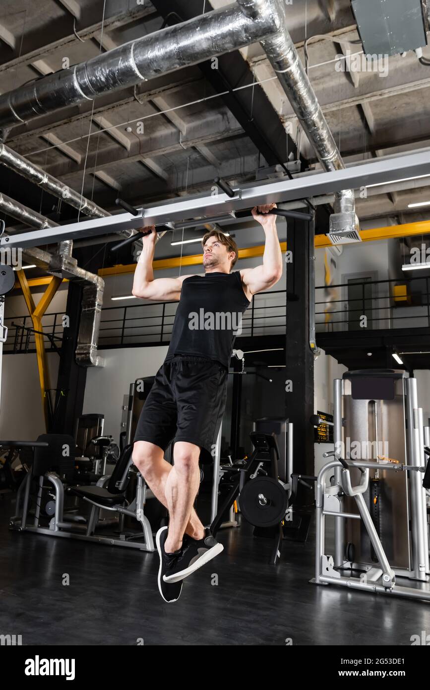full length view of young sportsman working out on horizontal bar Stock ...