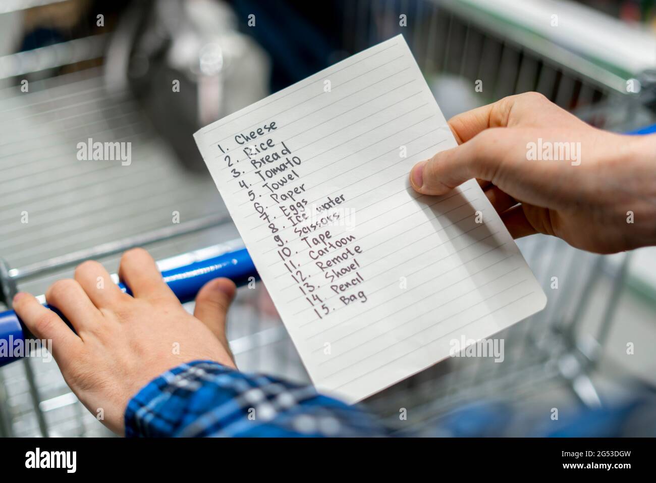 person's hands holding a shopping list paper sheet and check buying ...