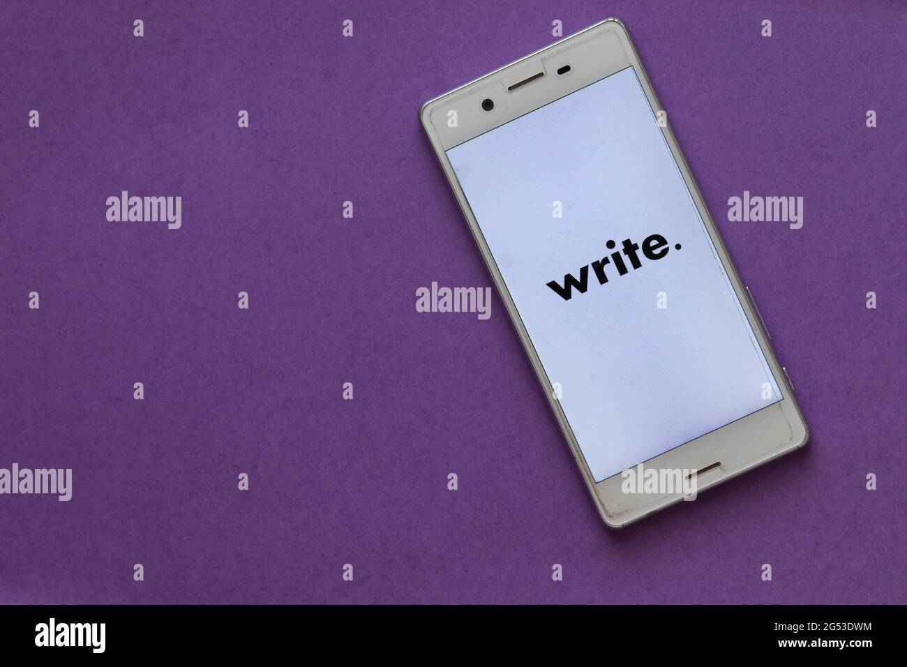 White cell phone on a purple background, the word "write" is written on ...