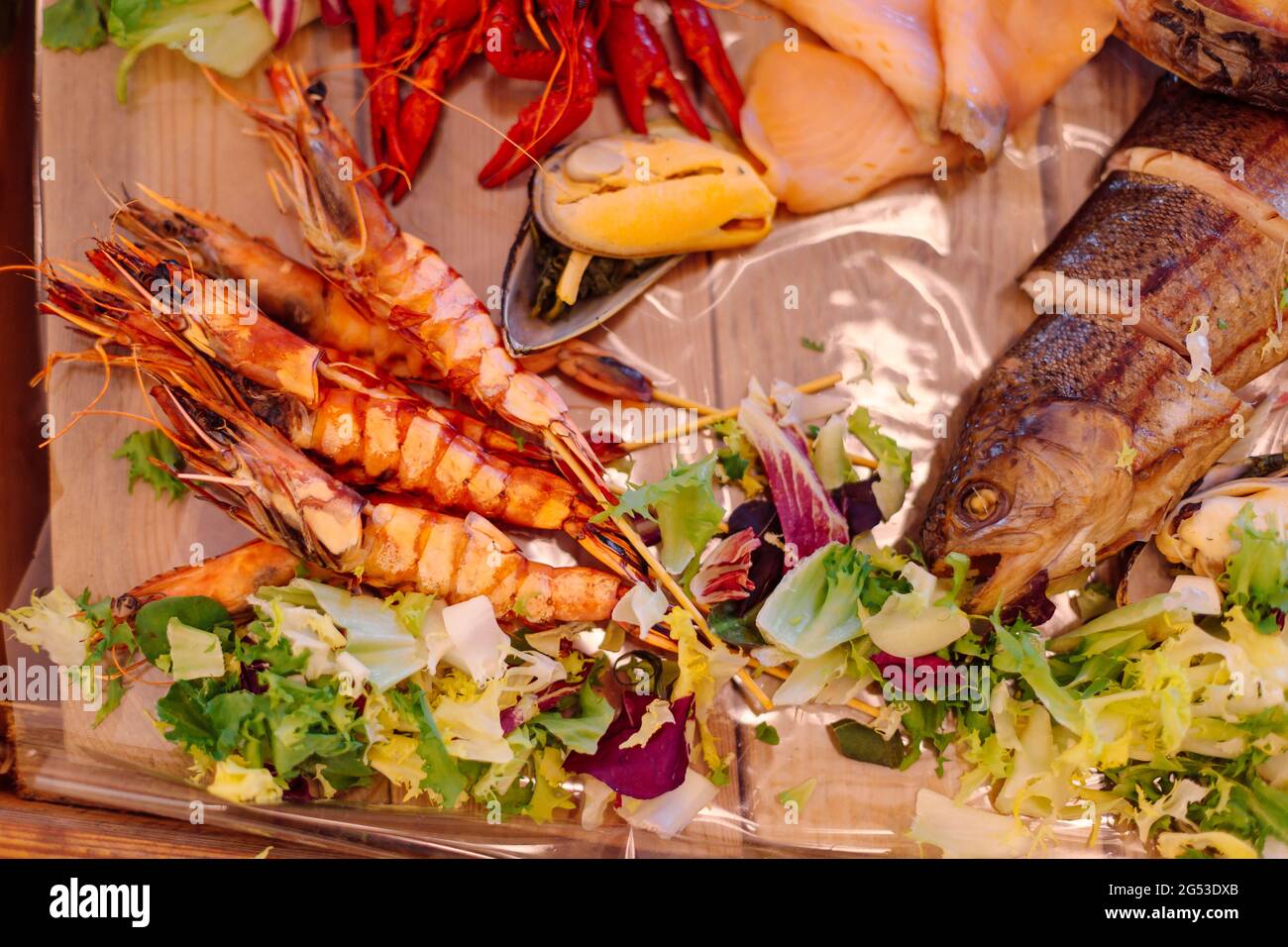 Assorted various seafood, laid out on wooden tray. Fish buffet at hotel ...