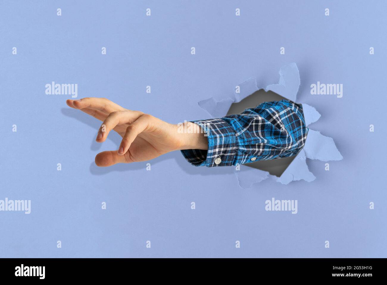 human hand reach the goal, raise through the hole in color paper Stock ...