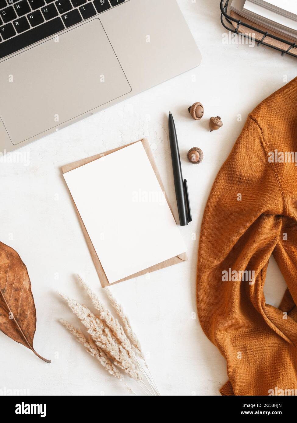 Home office desk with laptop, storage basket, brown sweater, fall leaf ...