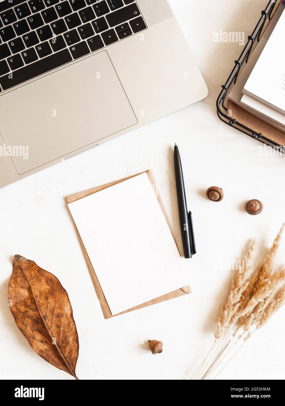 Home office desk with laptop, storage basket, dry flowers, envelopes ...