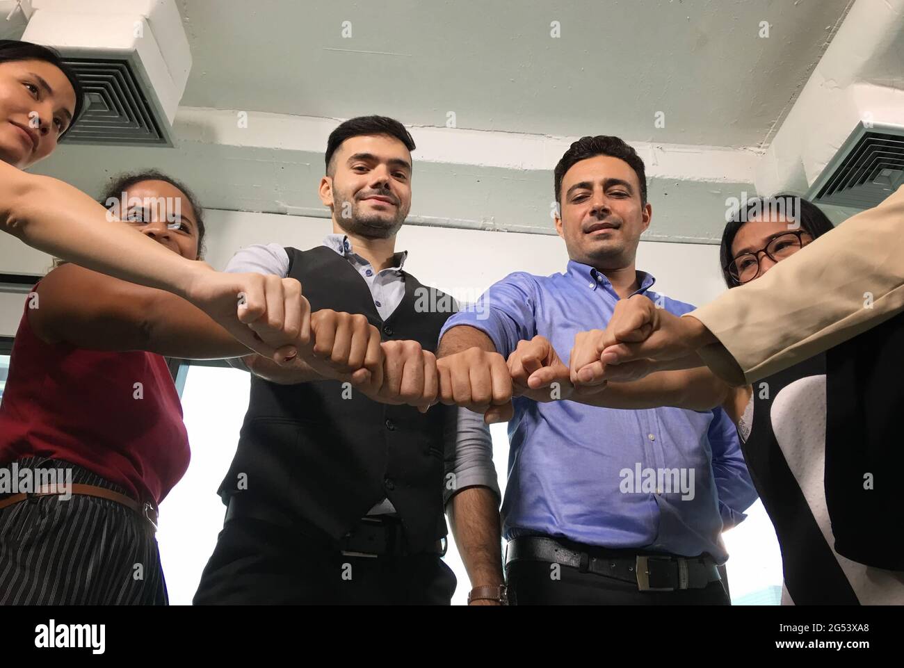 Business team showing unity with their hands together. Group of people joining hands and ...