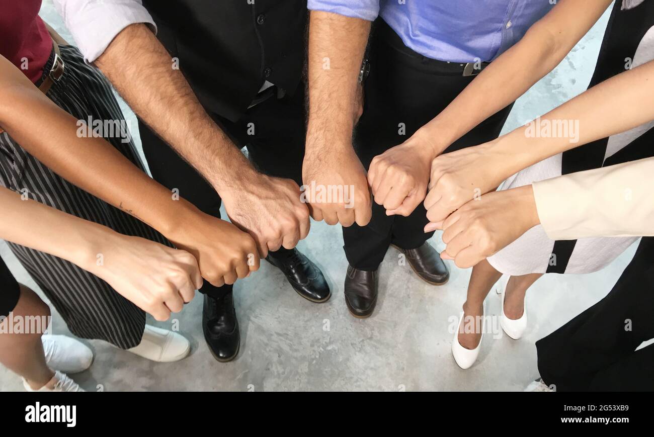 Business team showing unity with their hands together. Group of people joining hands and ...