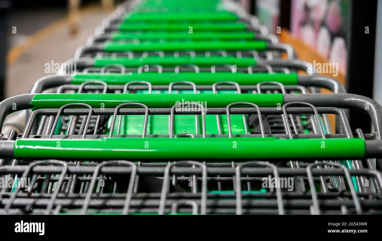 Shopping cart with green colors in line outside Stock Photo - Alamy