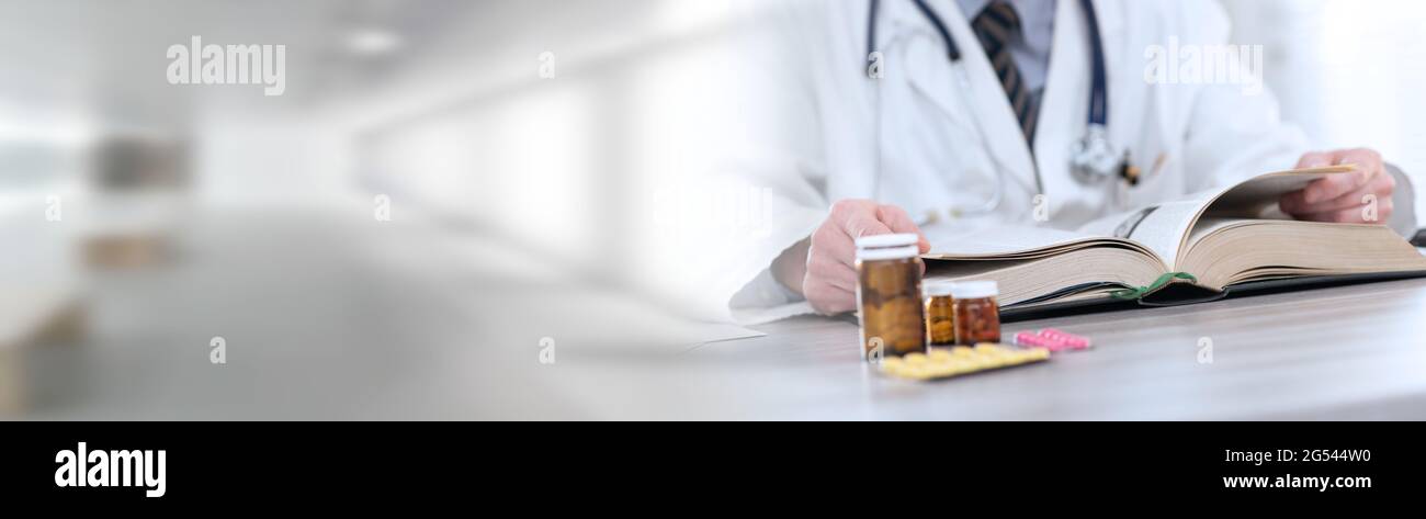 Doctor reading a textbook in medical office; panoramic banner Stock ...