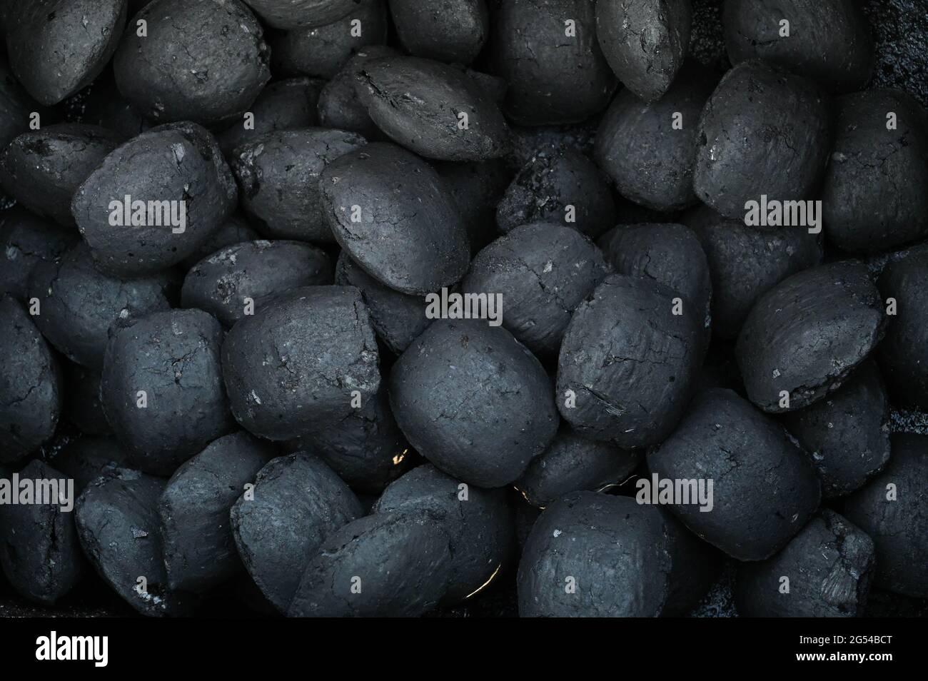 Close-up of an oval-shaped unburned charcoal grill drenched in fuel ...
