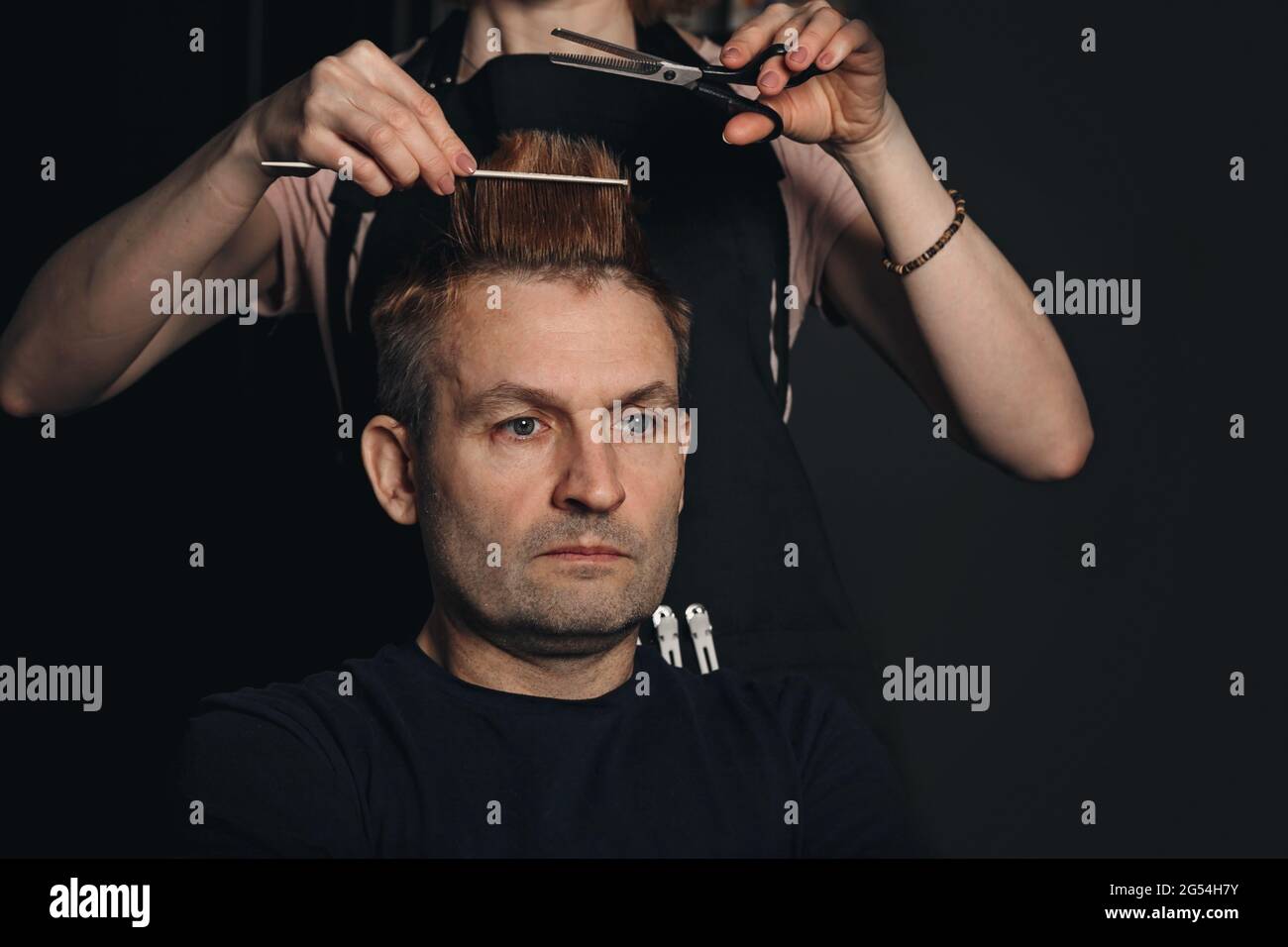 New trendy modern hairstyle. Barber is shearing man hair. Midle-aged ...