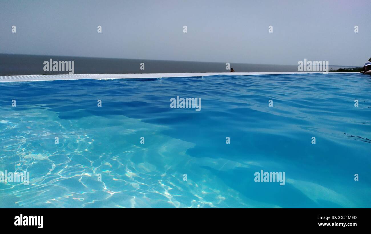 Infinity pool with blue water overlooking the sea Stock Photo - Alamy
