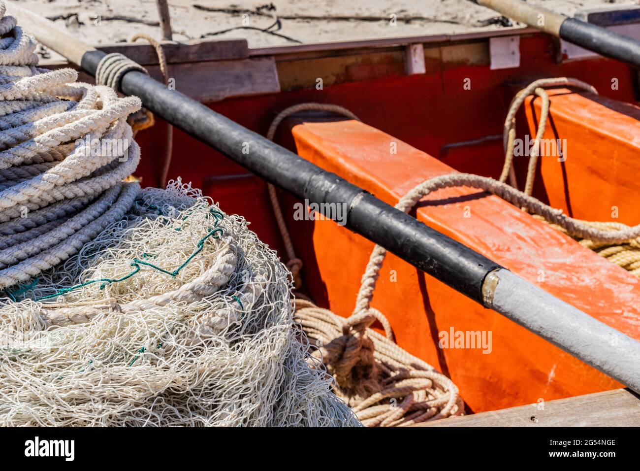 traditional fishing net and rope on small rowing boat on beach Stock ...