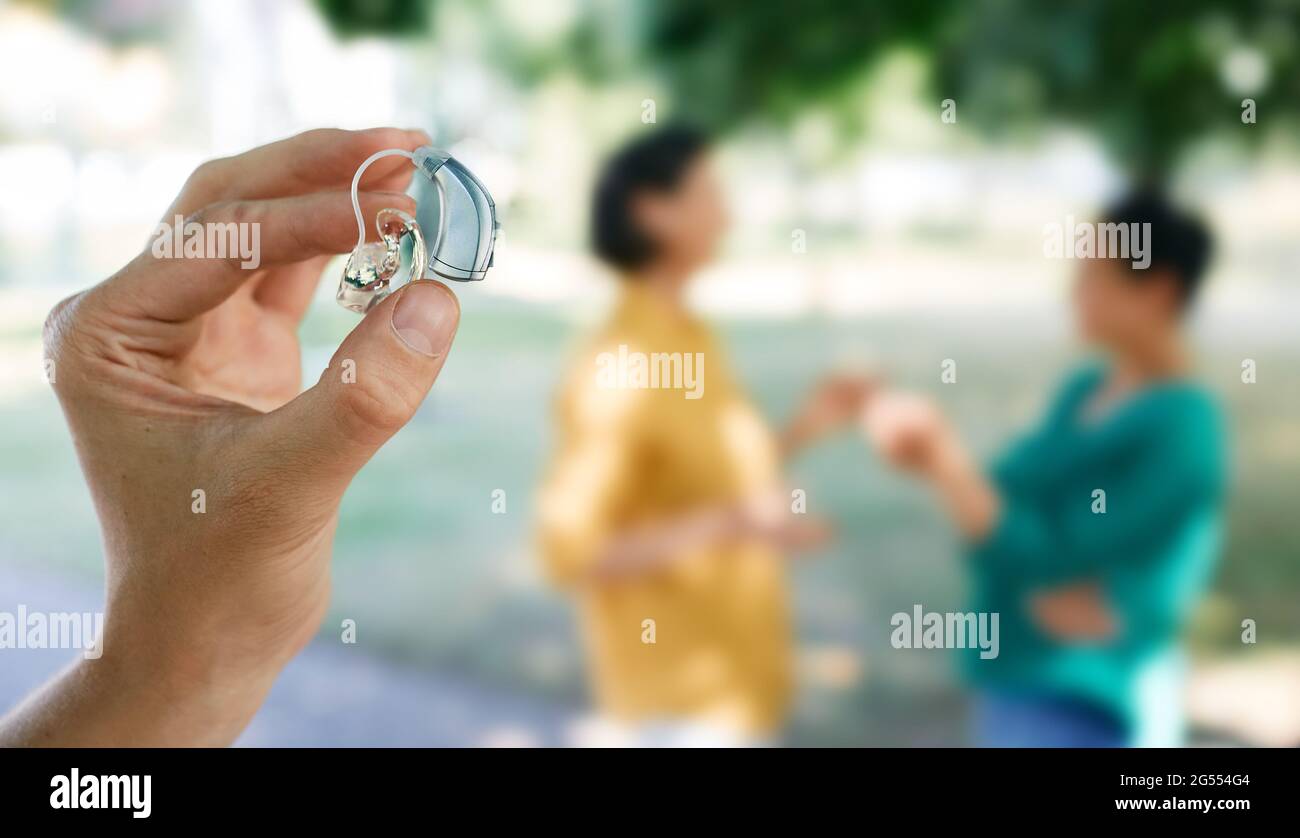 Hearing solutions. Last generation of hearing aid device in human hand ...