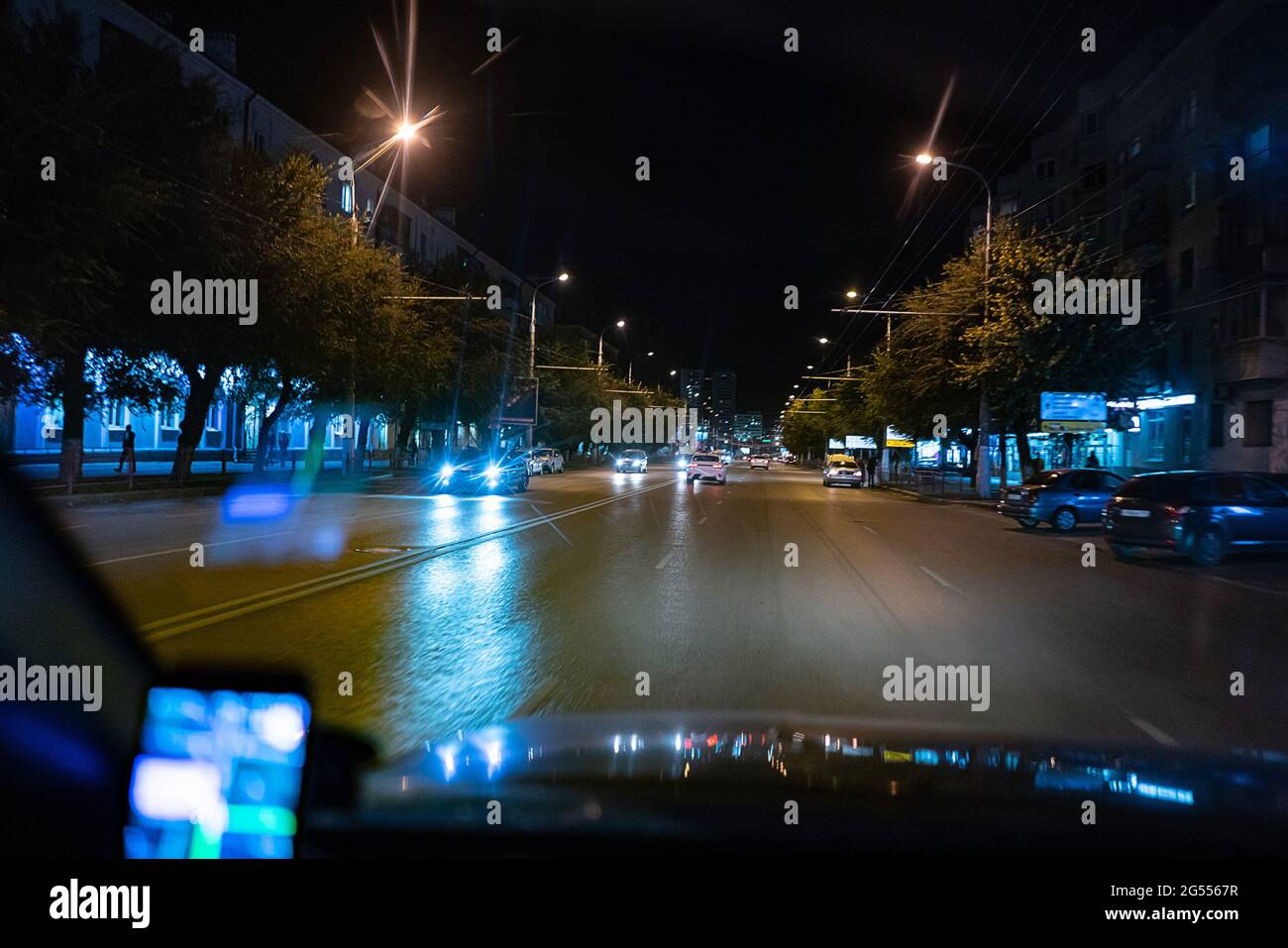 view from inside the car driving at night in the city traffic highway ...